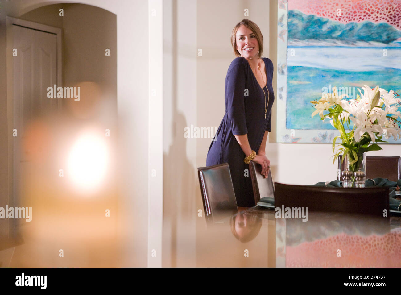 Young woman standing by dining table, side view Stock Photo - Alamy