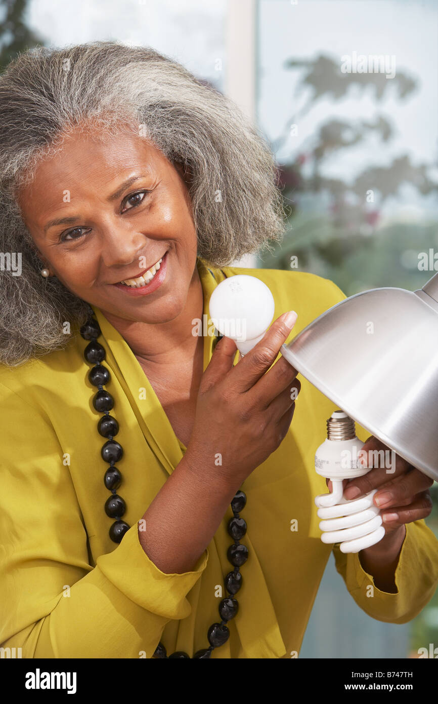 Woman changing light bulb hi-res stock photography and images - Alamy
