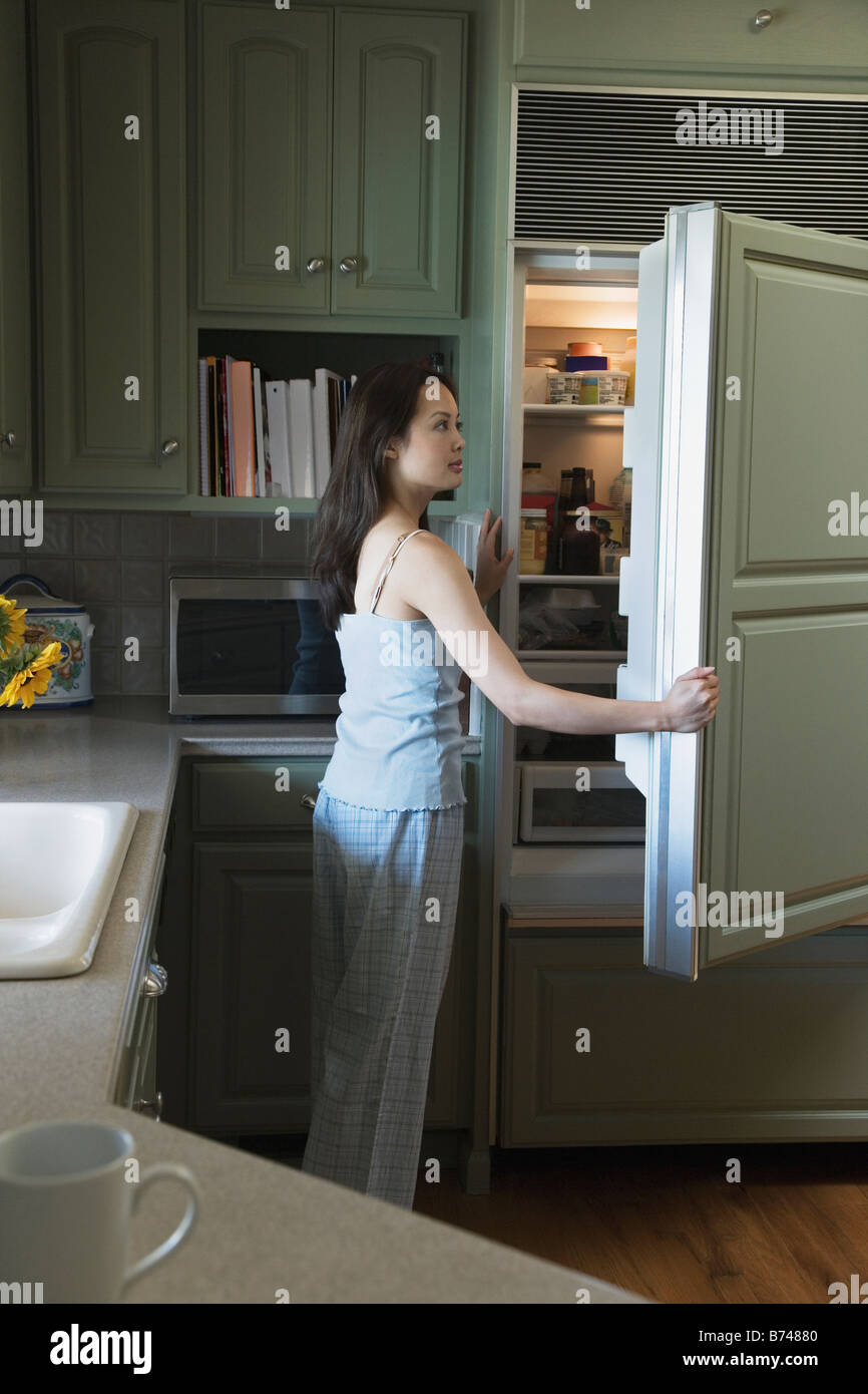 Woman opening refrigerator door Stock Photo - Alamy