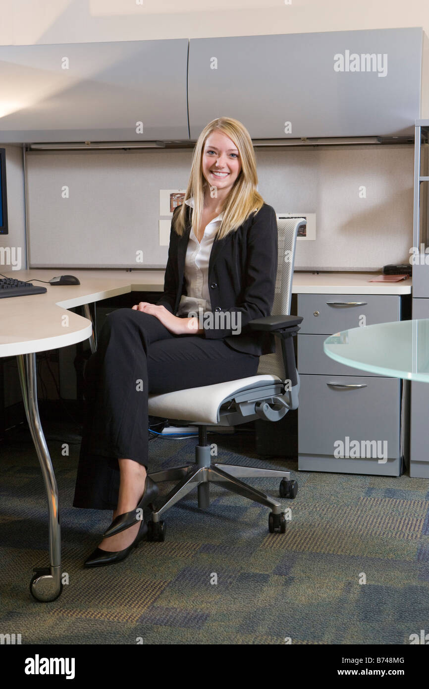 Young female office worker sitting at cubicle desk Stock Photo - Alamy