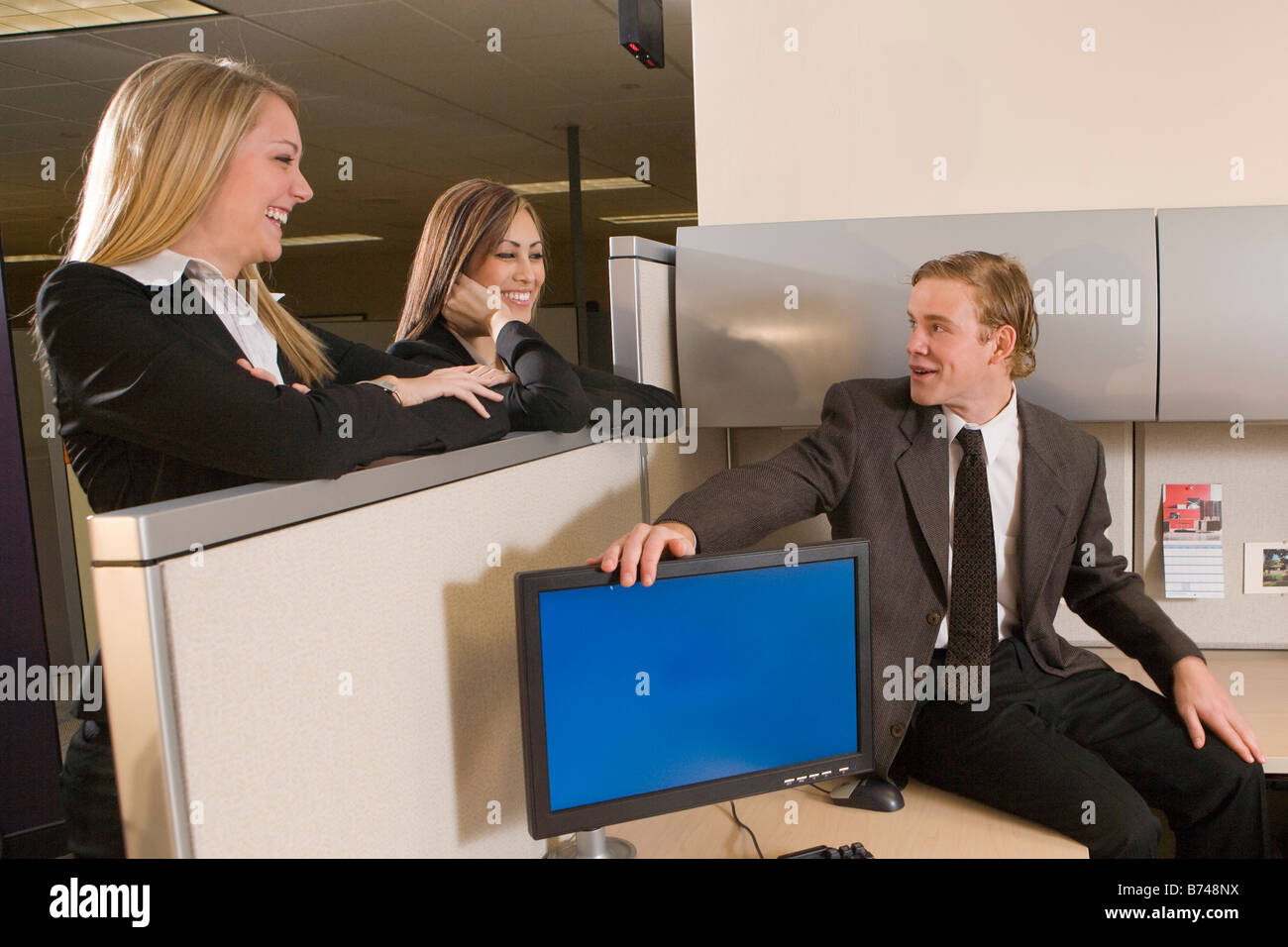 Office workers chatting at cubicle desk Stock Photo - Alamy