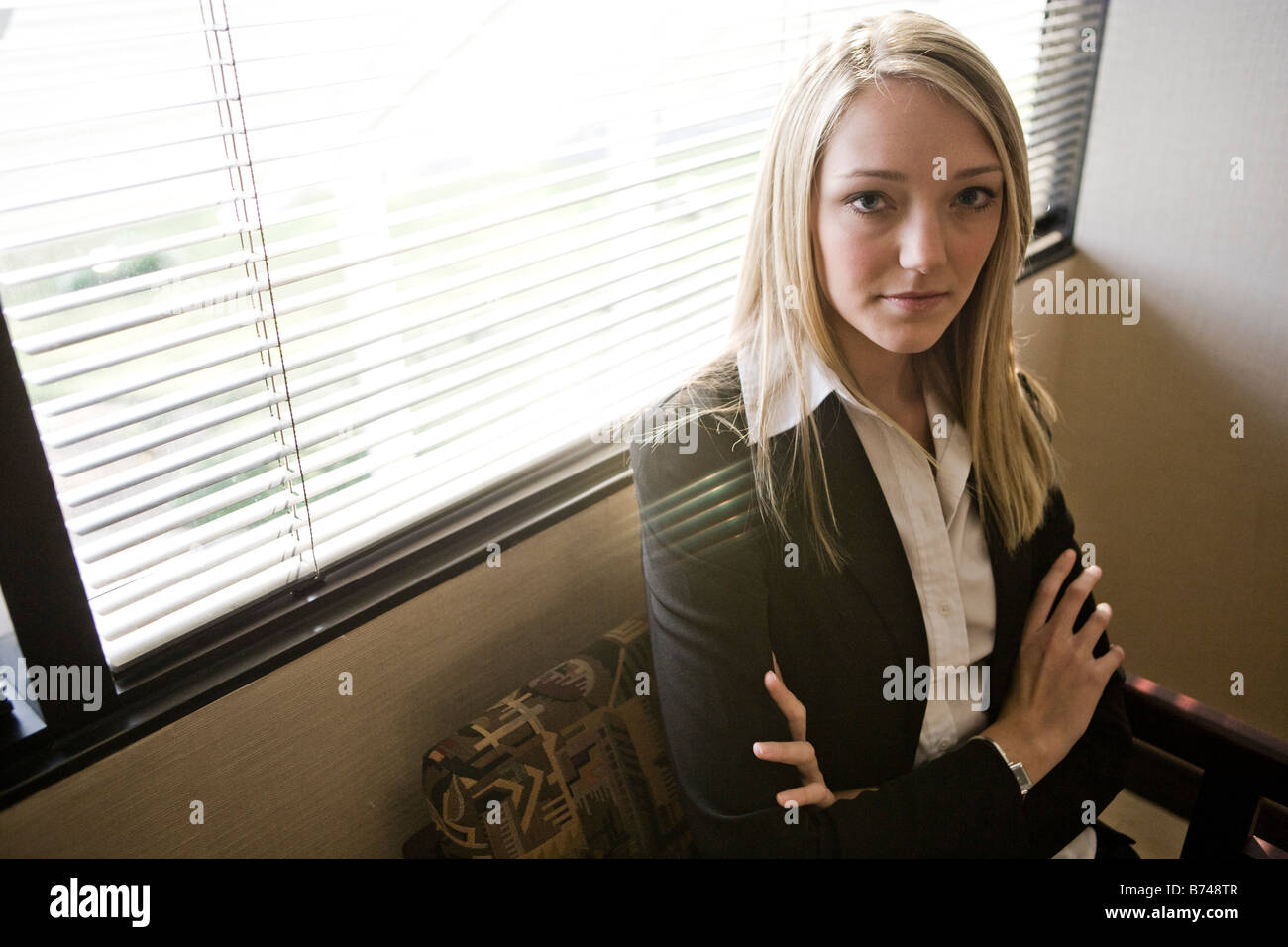 Young confident female office worker standing by window Stock Photo - Alamy