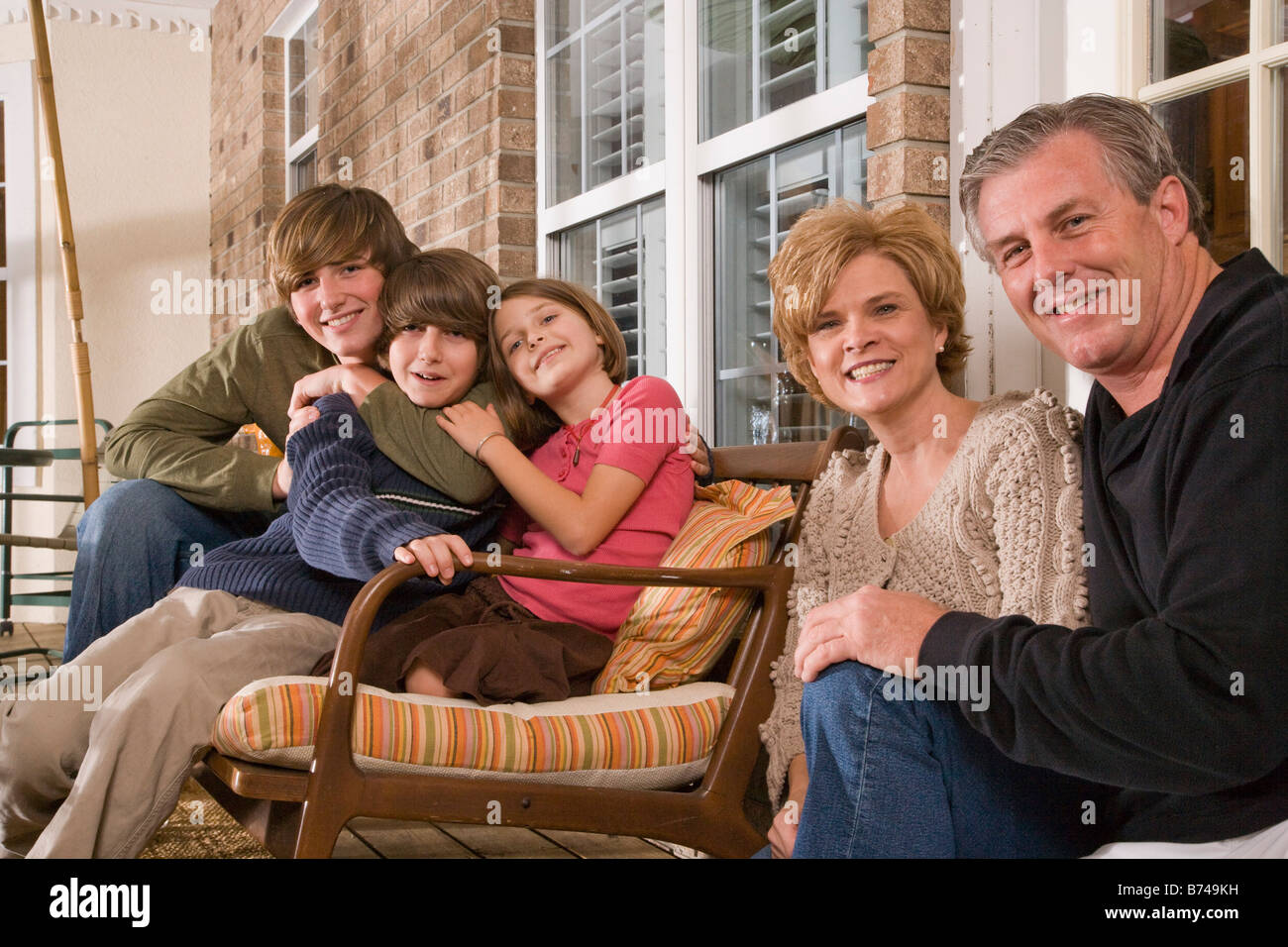 Portrait of family sitting together on porch Stock Photo - Alamy