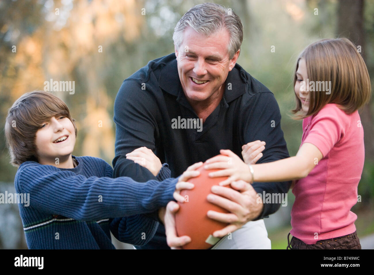 Two children playing football with father outdoors Stock Photo - Alamy