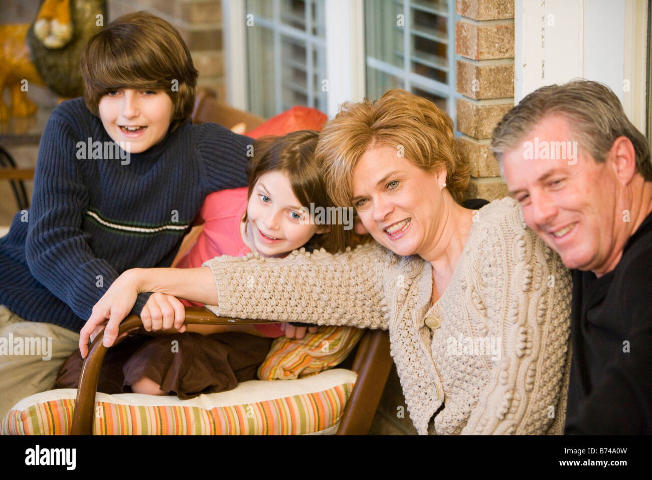 Portrait of family sitting together on porch Stock Photo - Alamy