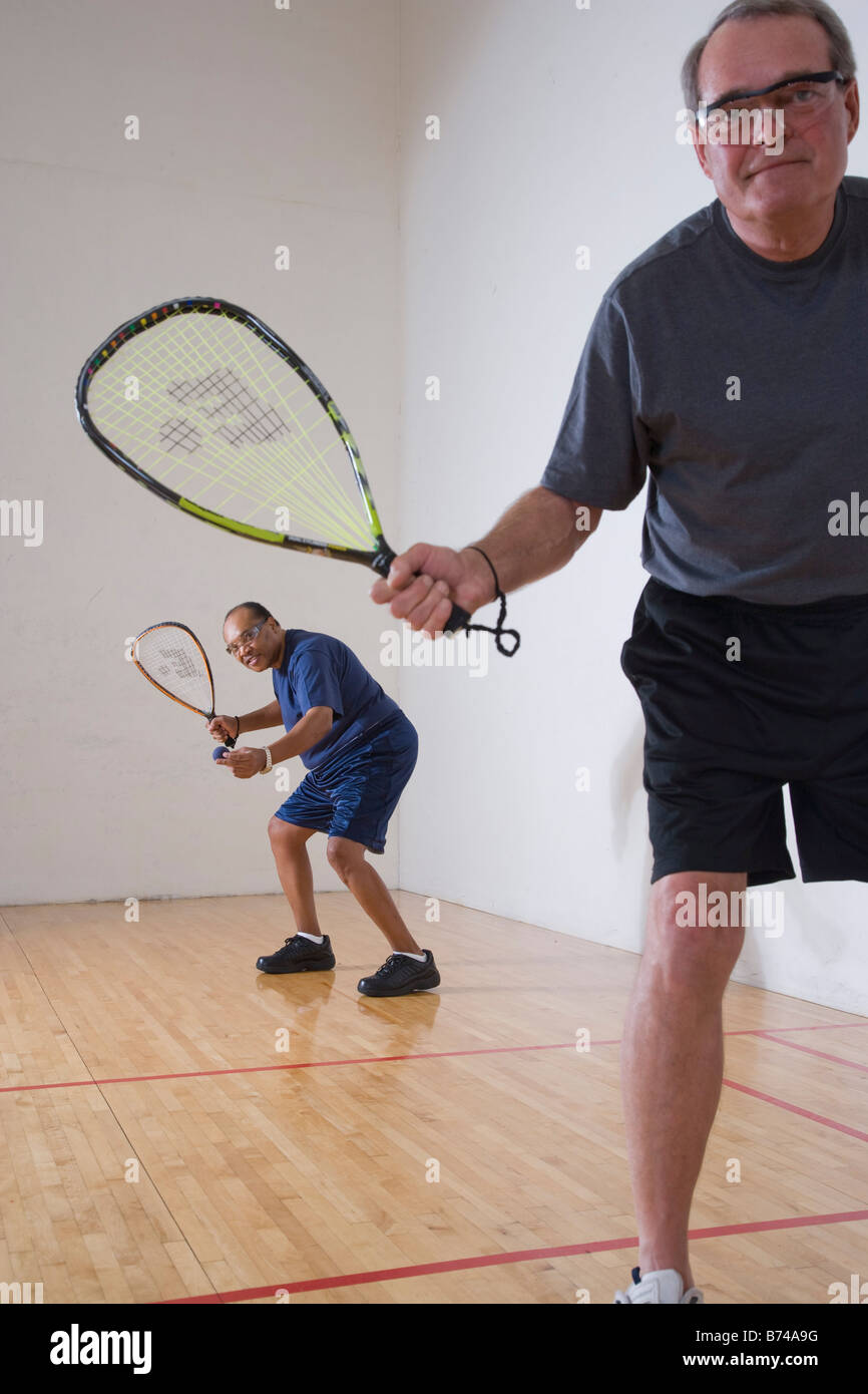 Multi-ethnic senior men playing racketball at indoor court Stock Photo ...