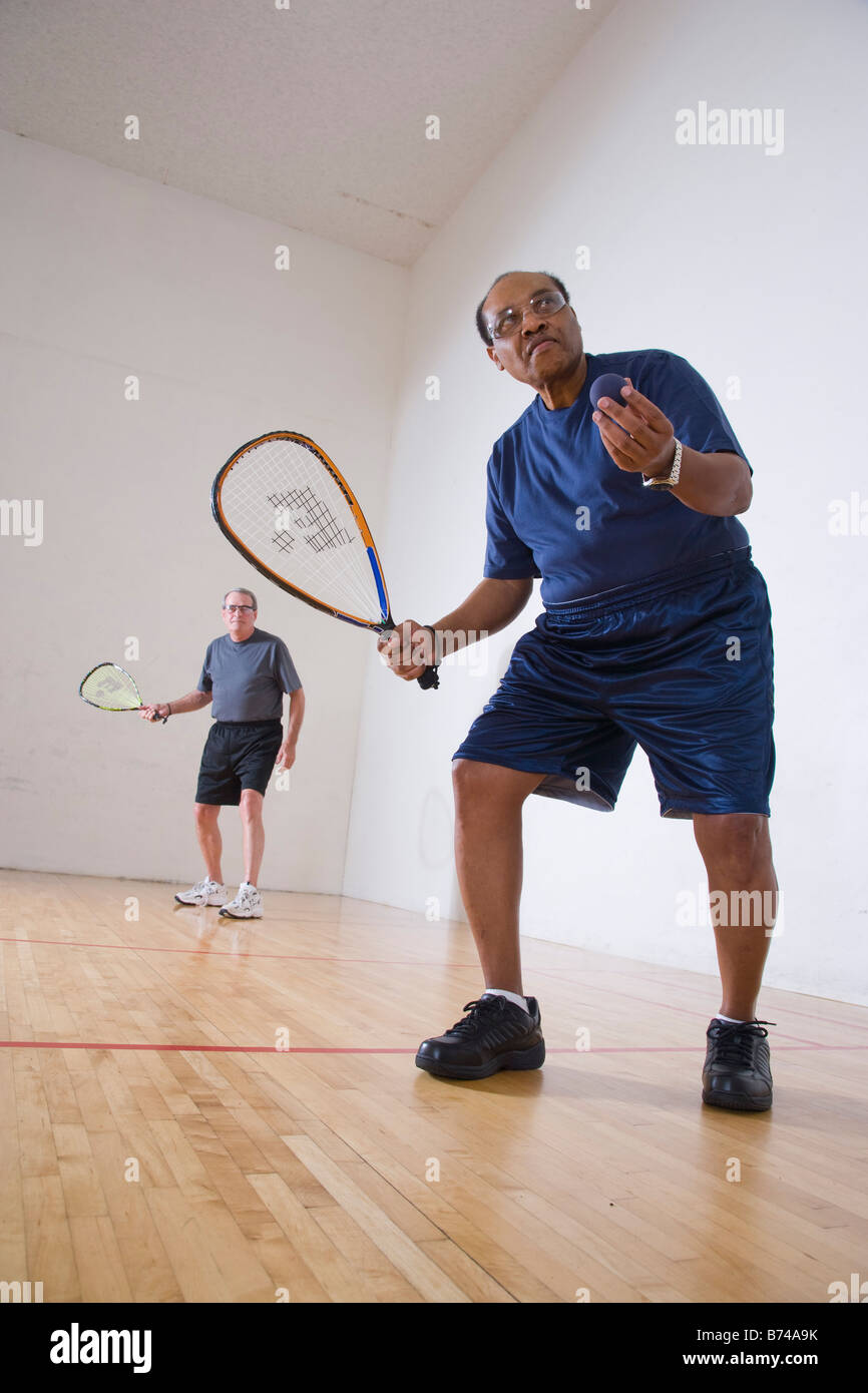 Multi-ethnic senior men playing racketball at indoor court Stock Photo ...