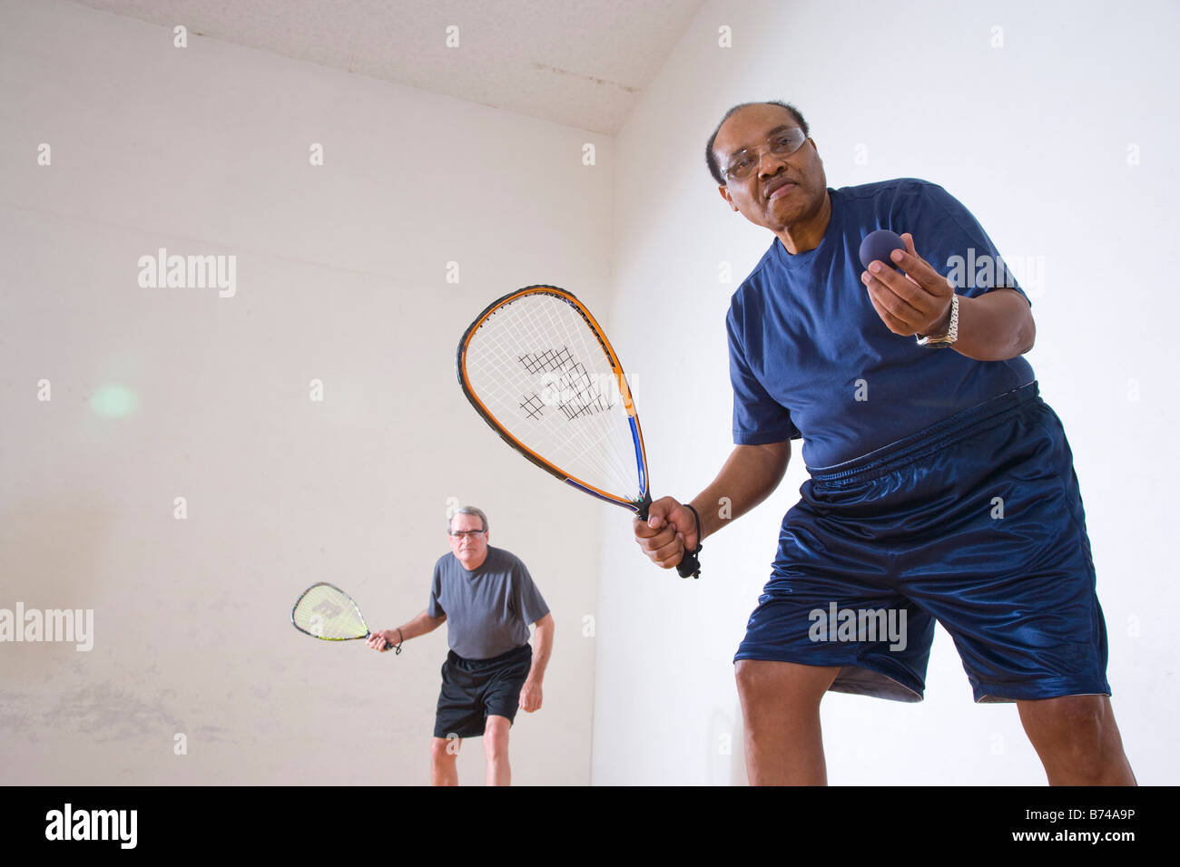 Multi-ethnic senior men playing racketball at indoor court Stock Photo ...