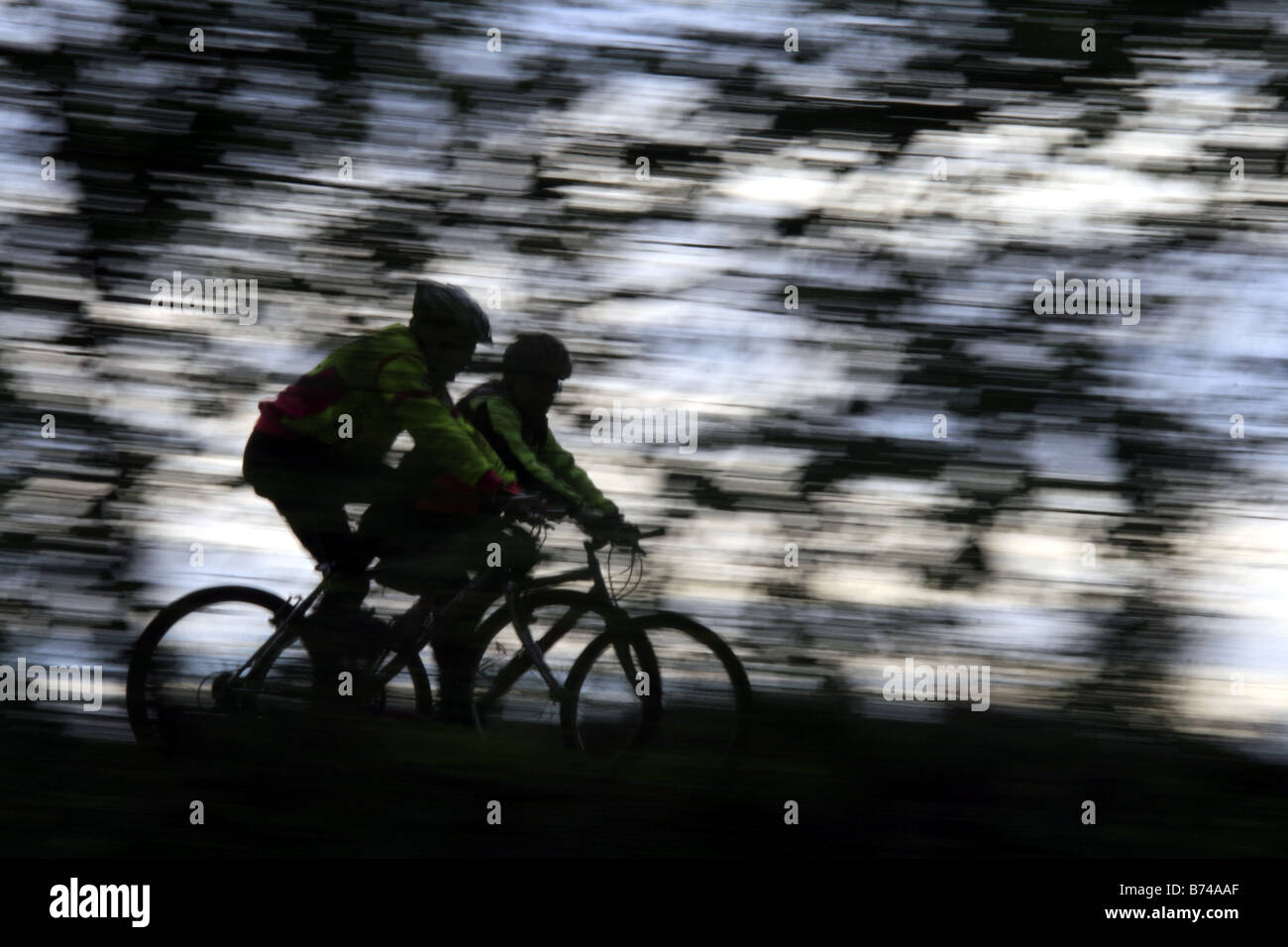 two people riding fast bikes on rural lane countryside Stock Photo - Alamy
