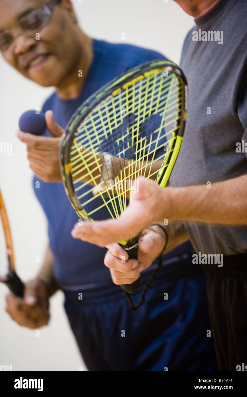 Multi-ethnic senior men playing racketball at indoor court Stock Photo ...
