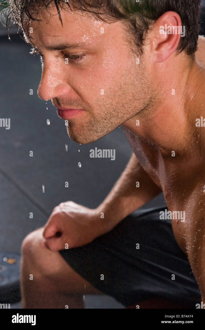 Young man sweating after workout in gym Stock Photo - Alamy