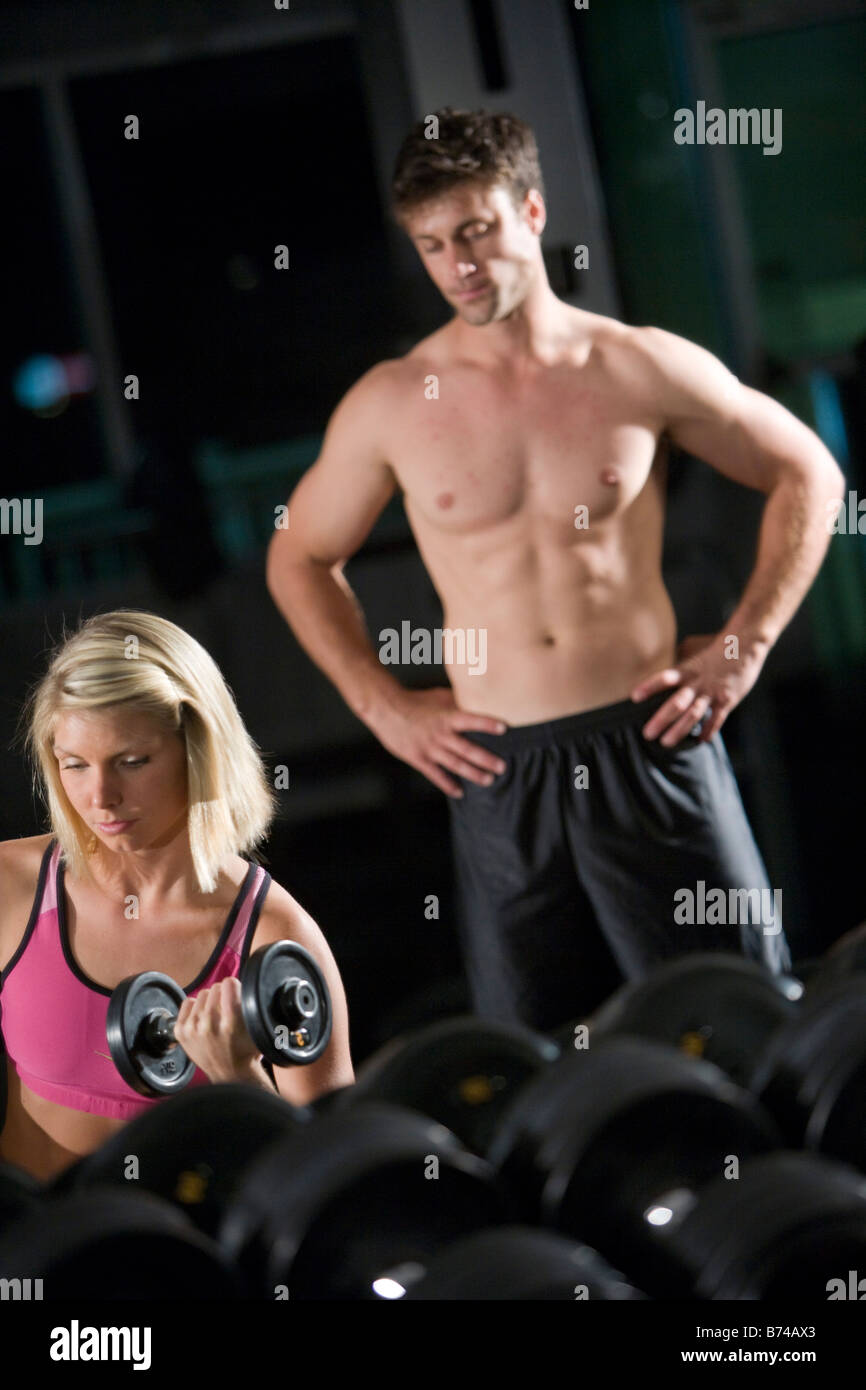 Physically fit young couple working out in gym Stock Photo - Alamy
