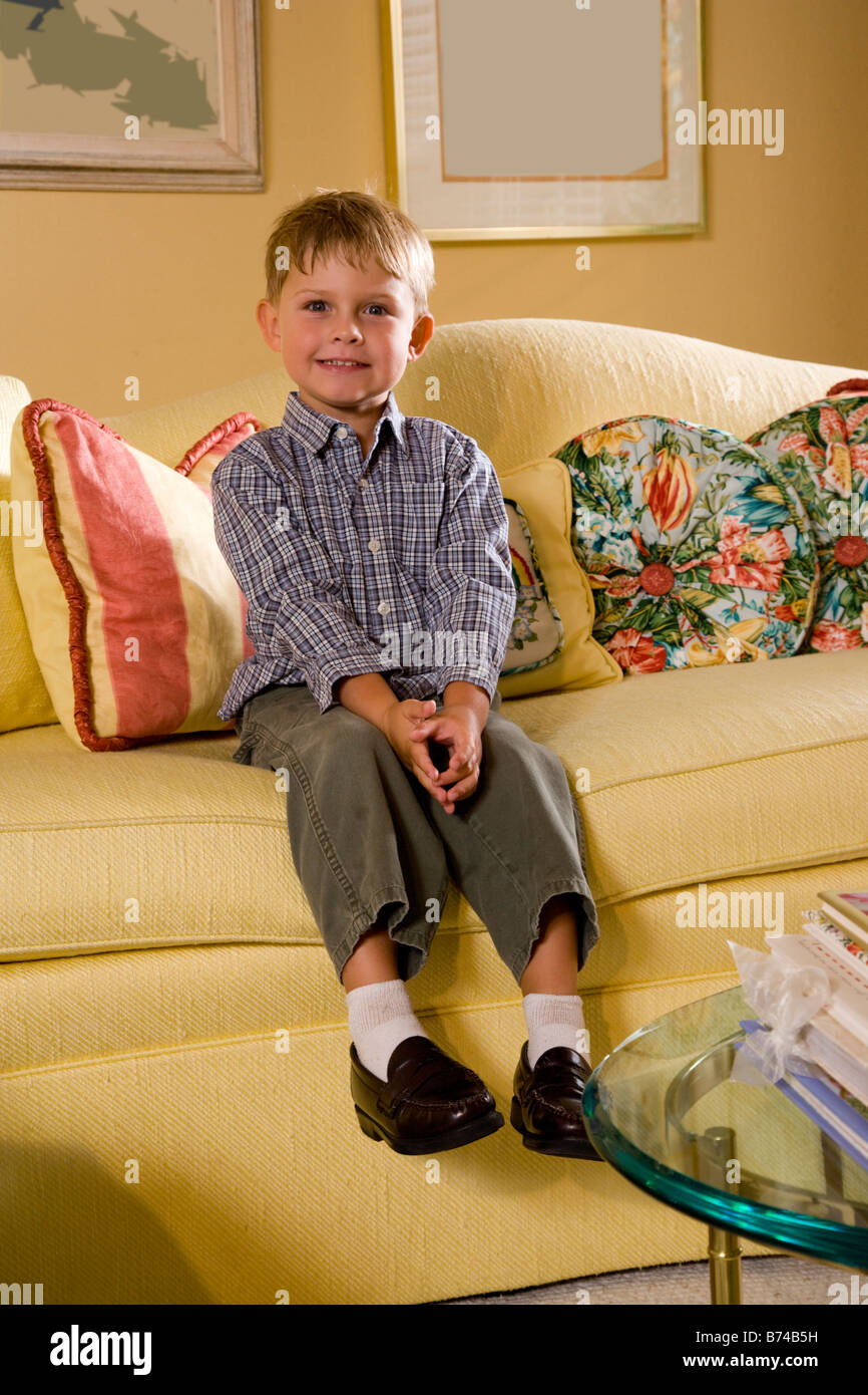 Portrait of happy young boy sitting on sofa Stock Photo - Alamy