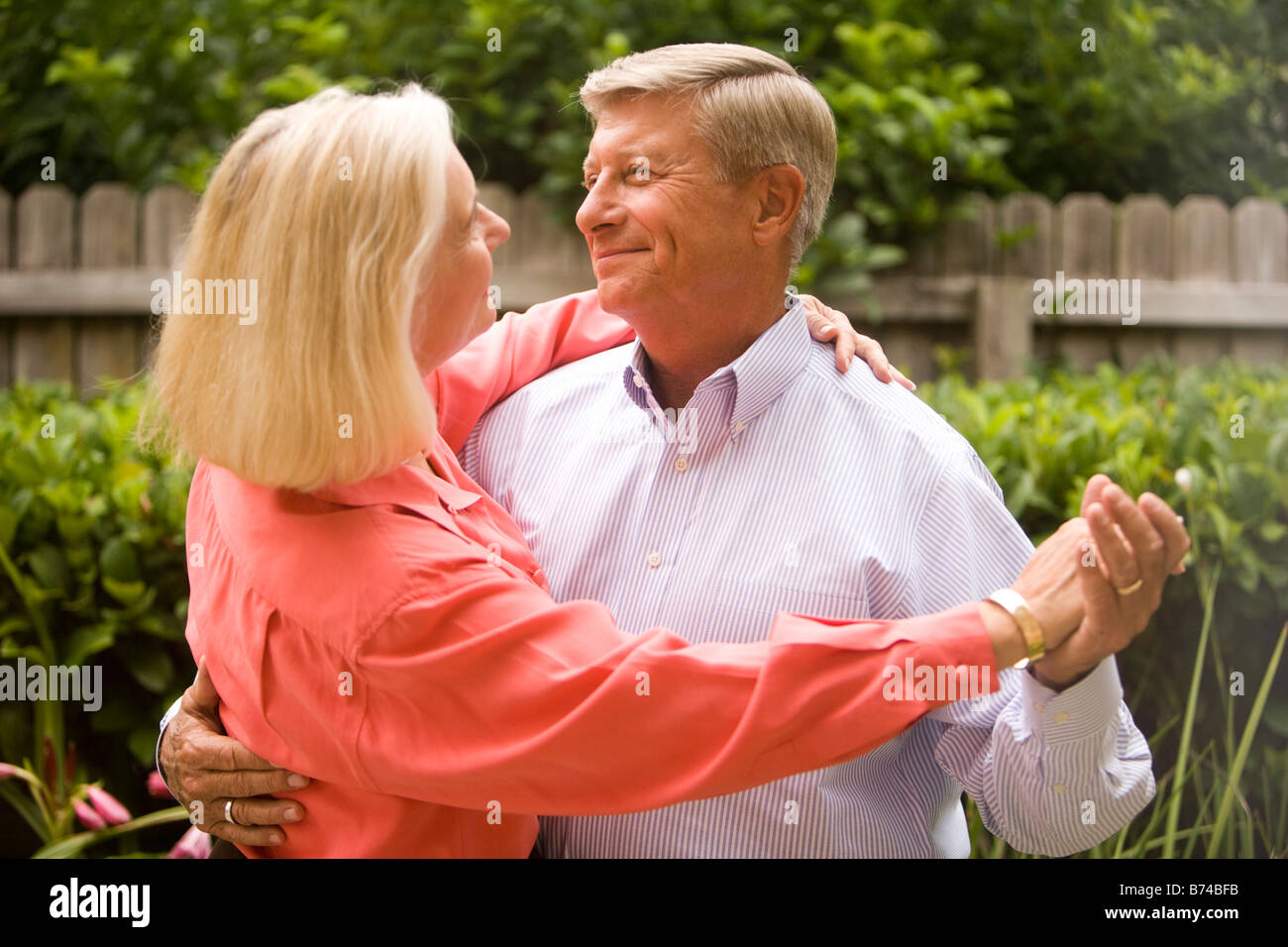 Loving senior couple dancing in garden Stock Photo - Alamy