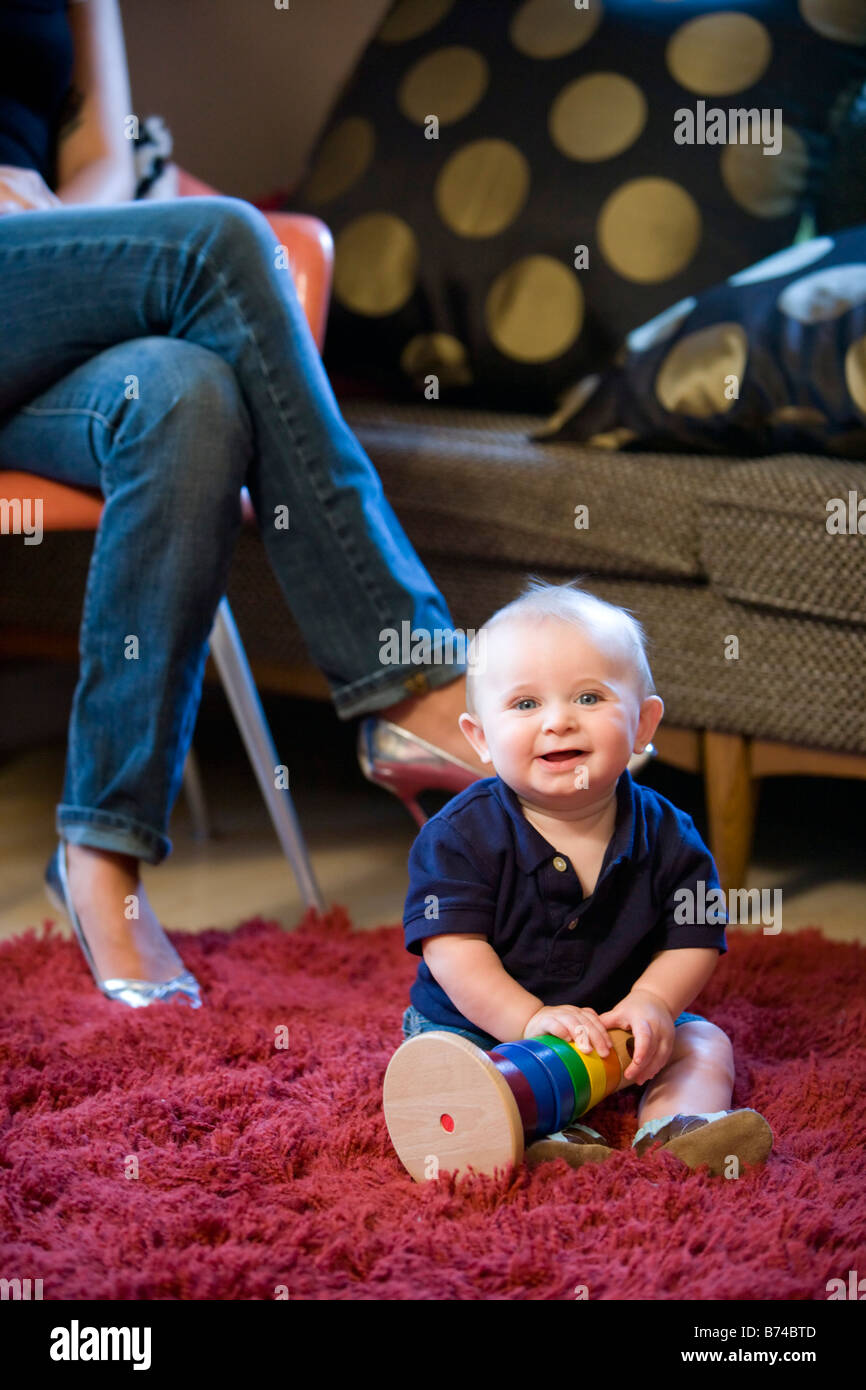 Baby boy sitting on rug Stock Photo - Alamy