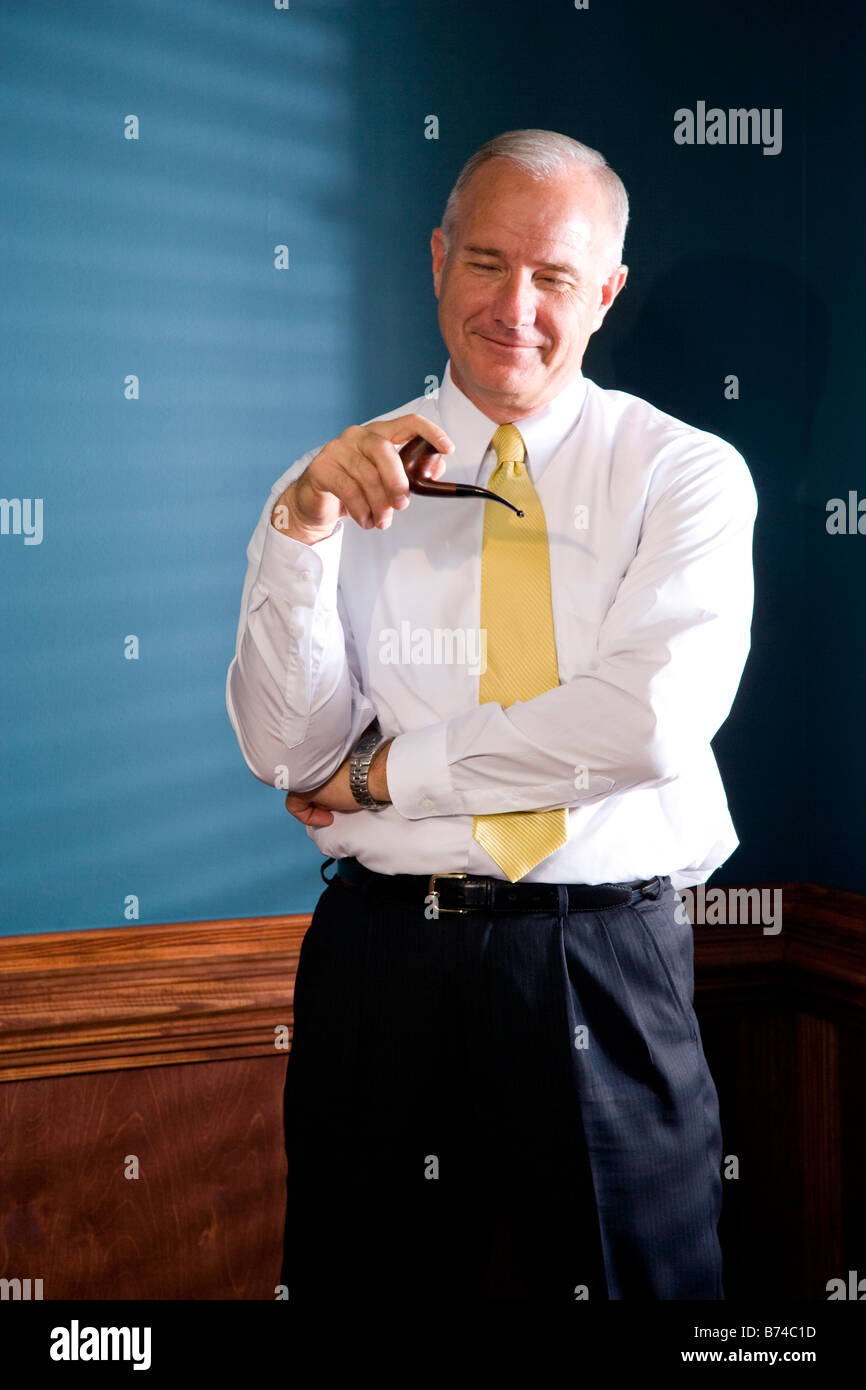 Businessman standing in conference room holding pipe Stock Photo - Alamy