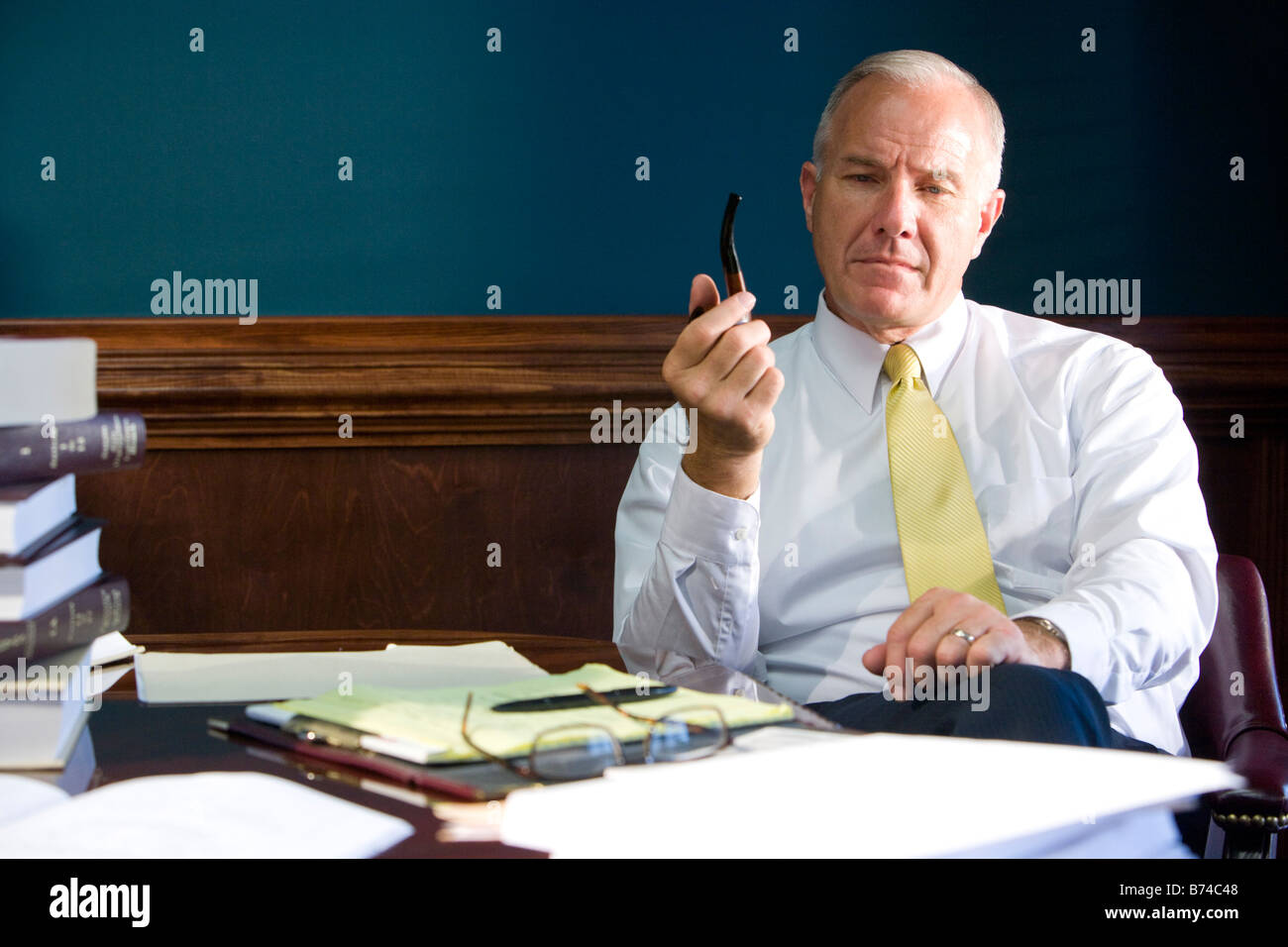 Businessman sitting in office smoking pipe Stock Photo - Alamy