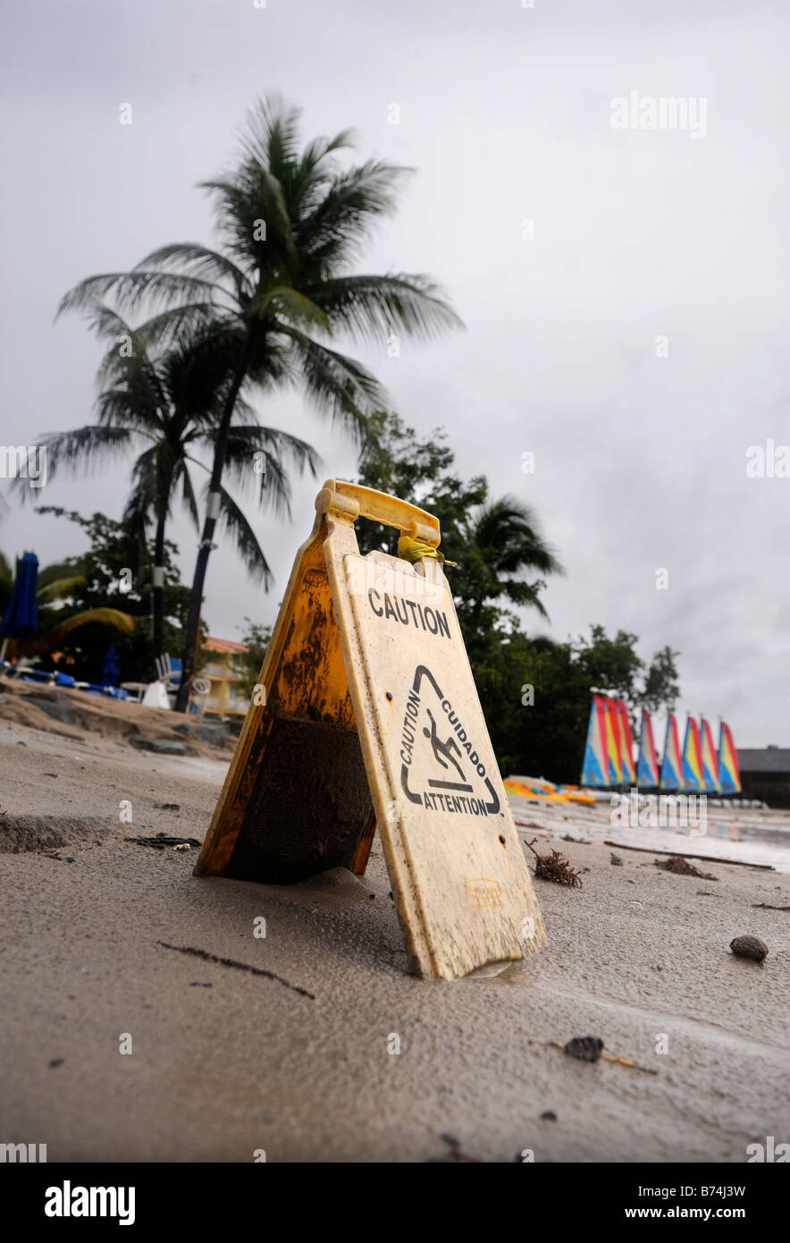 A WARNING SIGN ON AN EMPTY BEACH DURING A RAIN STORM AT A CARIBBEAN ...