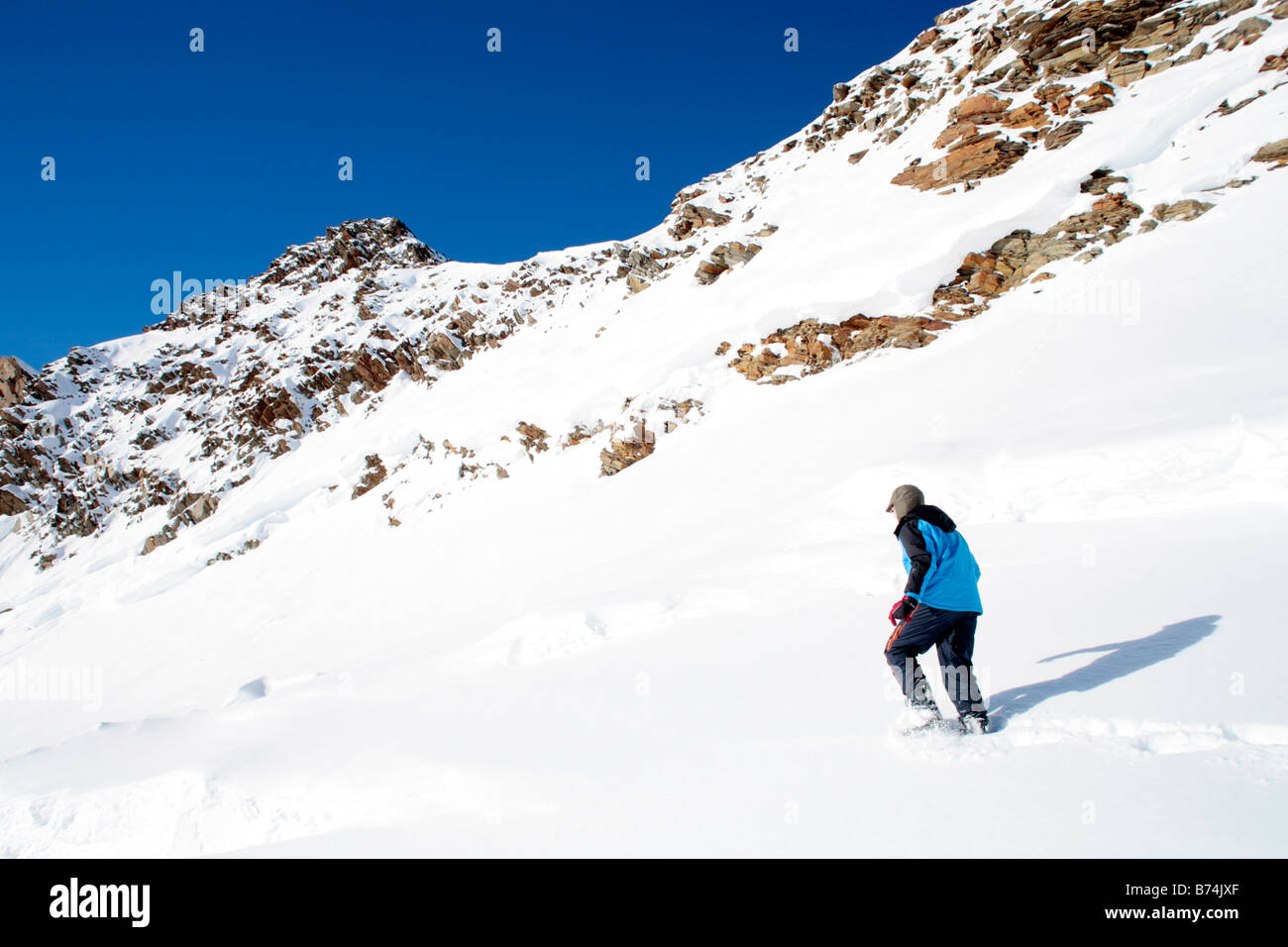 a young boy walking through deep snow at mountain station Schaufeljoch ...