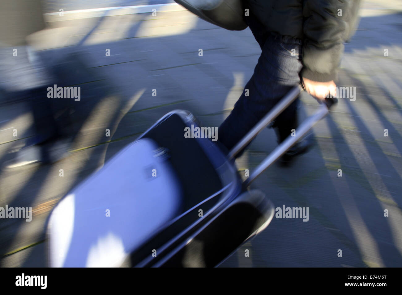 young man pulling trolley luggage case in town Stock Photo - Alamy