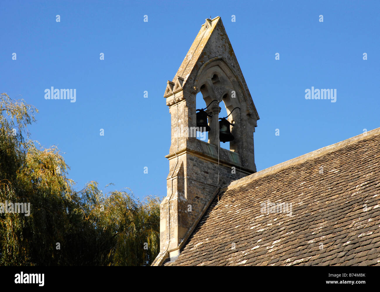 Two bells in bell gable on gable of church wall with cloudless blue sky ...