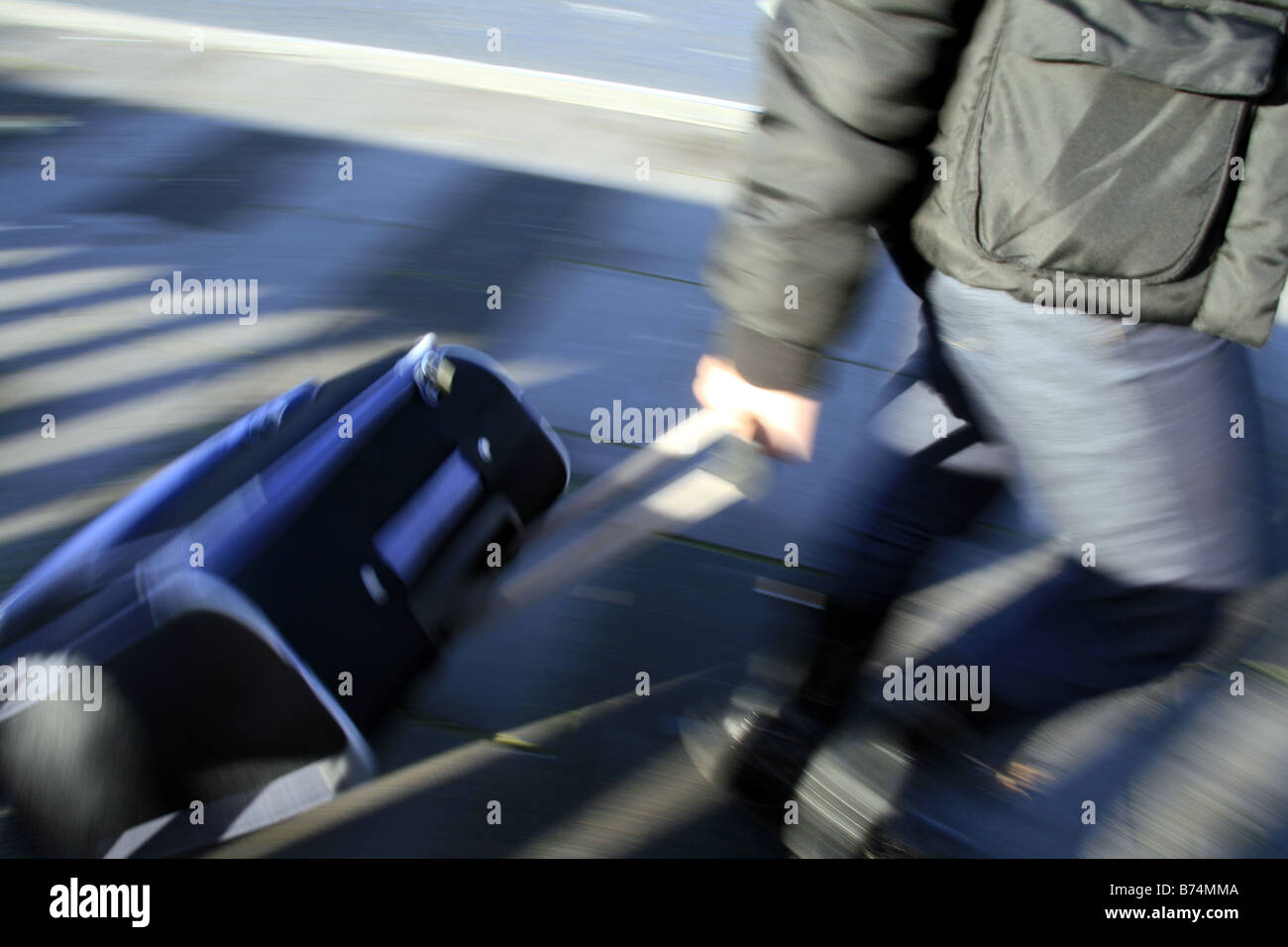young man pulling trolley luggage case in town Stock Photo - Alamy