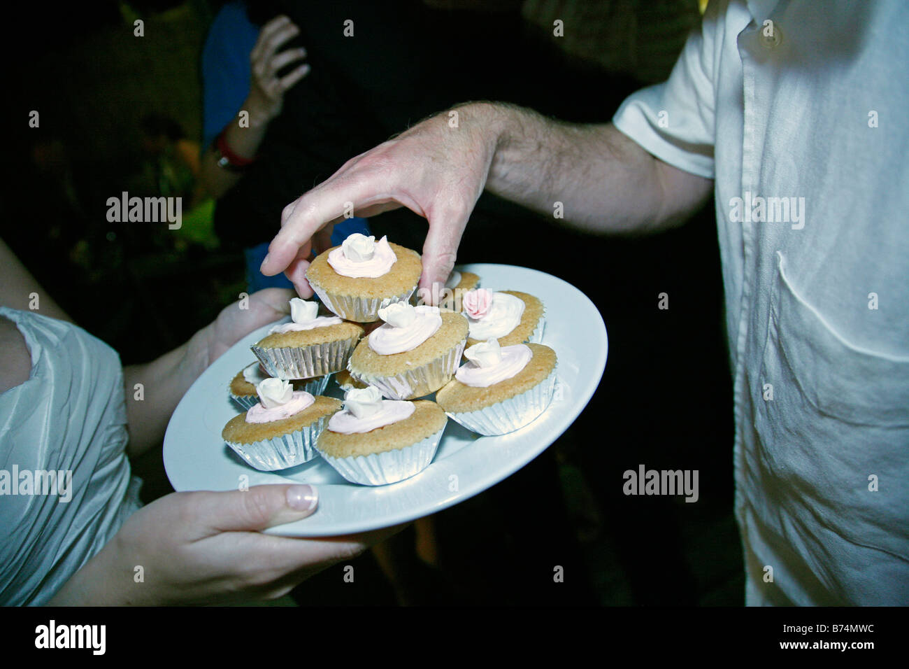 Bride handing wedding cakes to guests at her wedding reception Stock ...