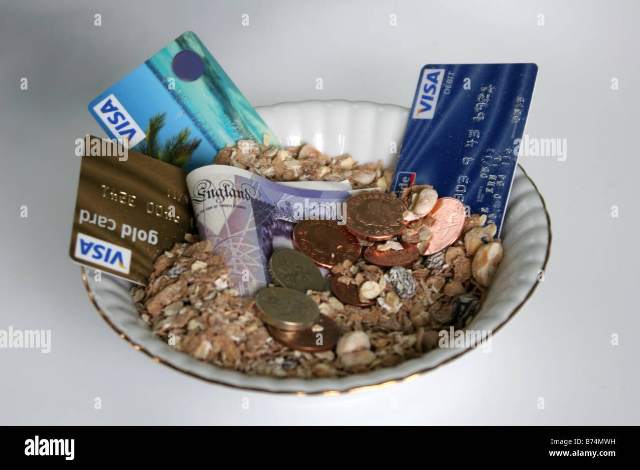 a bowl of credit crunch credit cards notes and coins typifying a ...