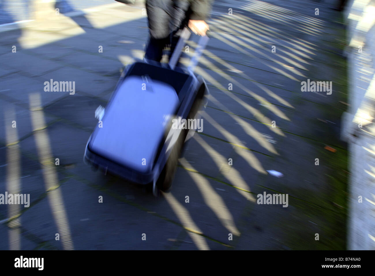 young man pulling trolley luggage case in town Stock Photo - Alamy