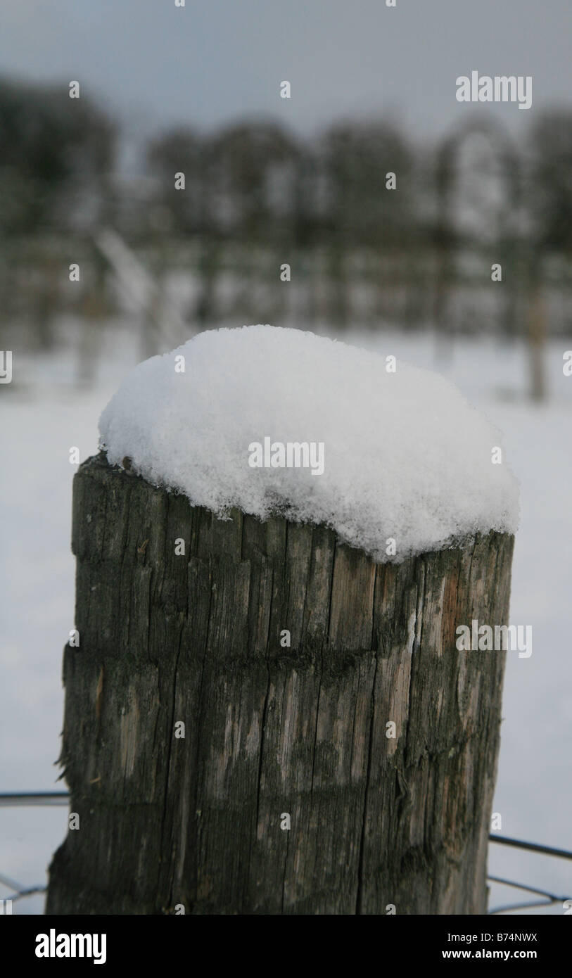 A wooden fence post covered in snow Stock Photo - Alamy