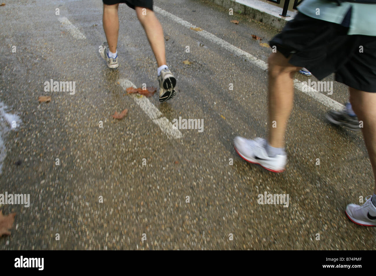 three runners in action on country lane in road race Stock Photo - Alamy