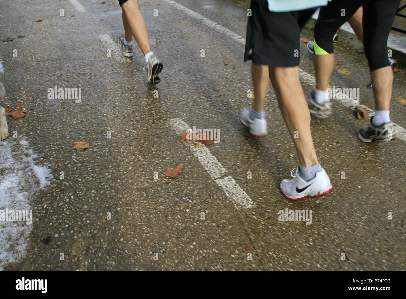 three runners in action on country lane in road race Stock Photo - Alamy