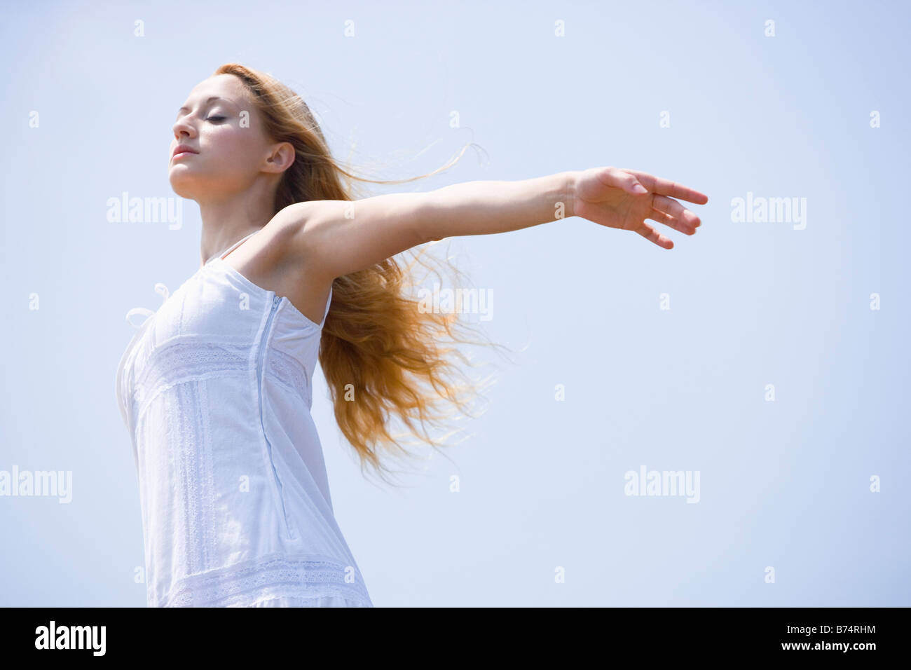 Young woman standing with arms outstretched Stock Photo - Alamy