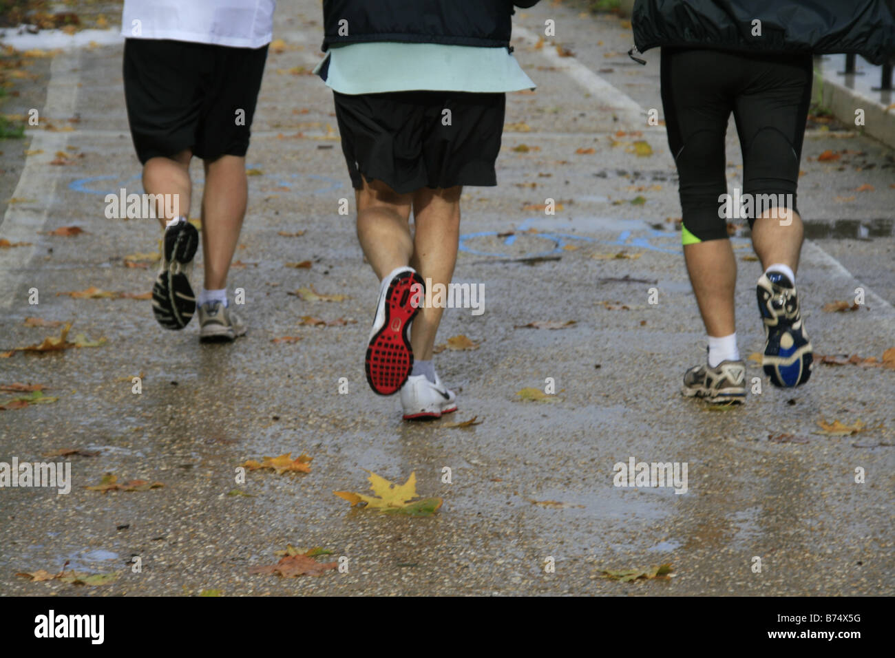 three runners in action on country lane in road race Stock Photo - Alamy