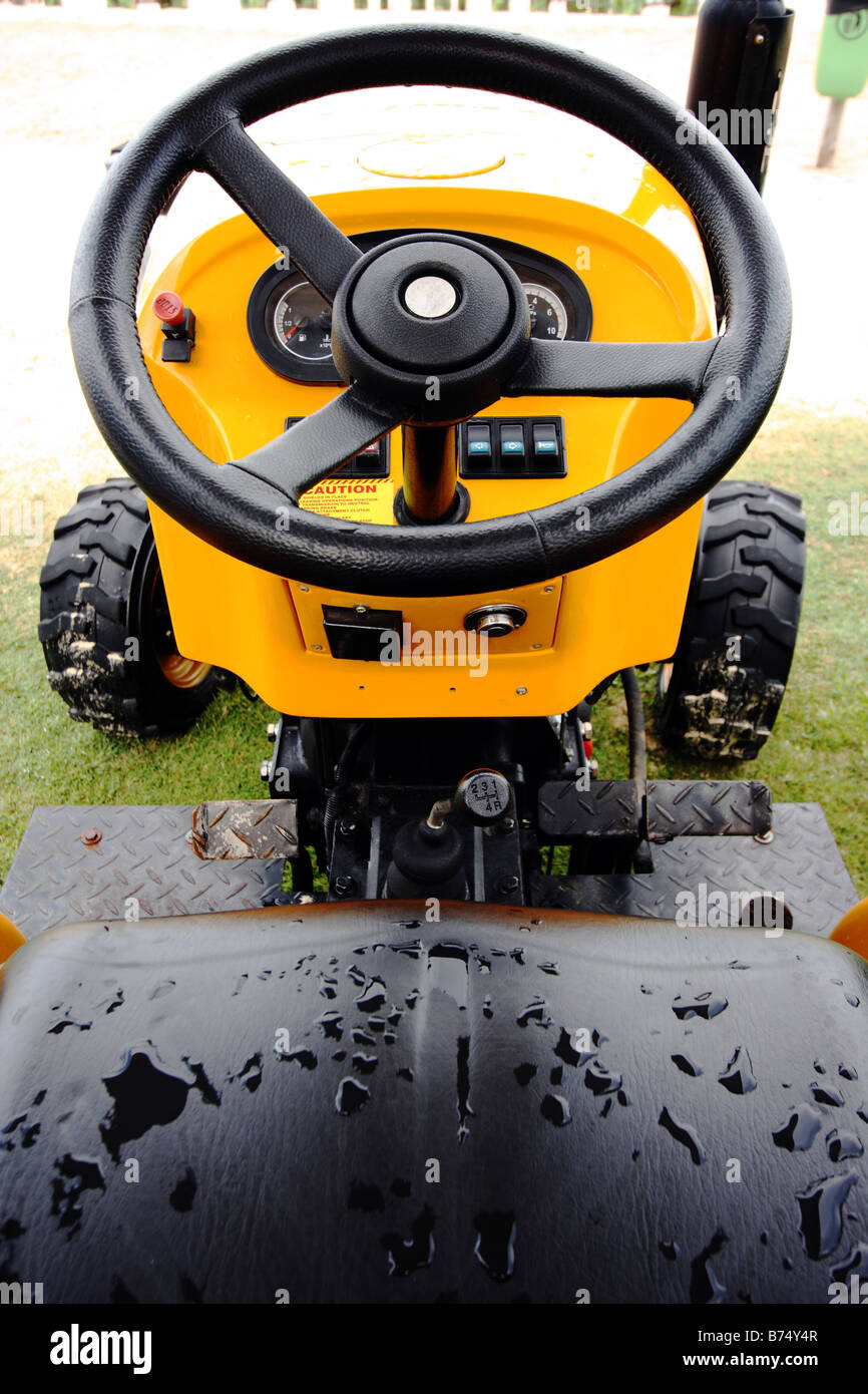 A WET YELLOW 4WD MINI TRACTOR USED FOR TOWING ON A BEACH VERTICAL ...