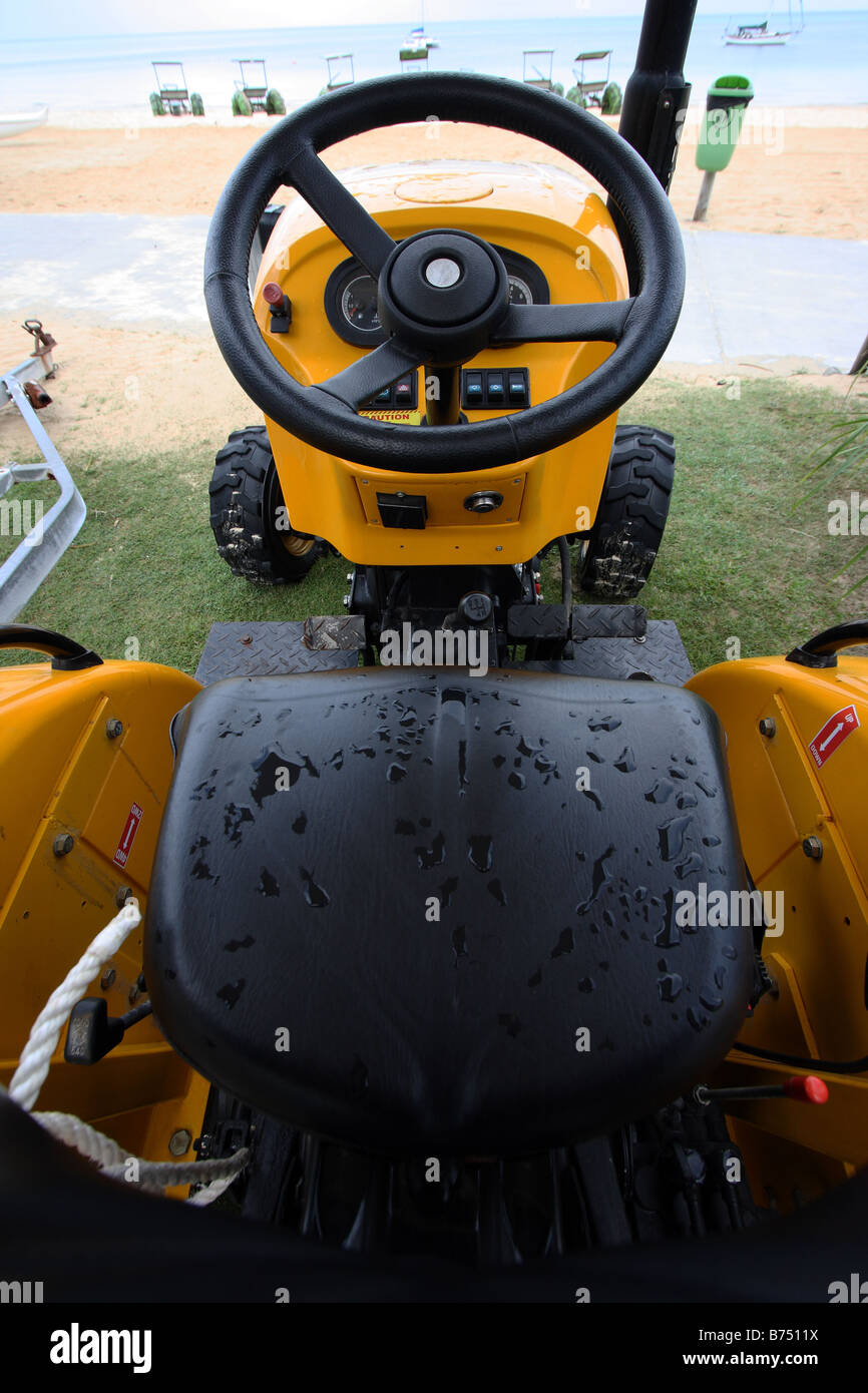 A WET YELLOW 4WD MINI TRACTOR USED FOR TOWING ON A BEACH VERTICAL ...