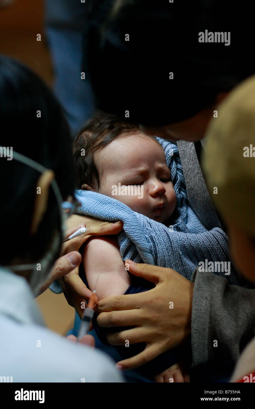 Young newborn Asian Caucasian baby boy recieve immunization shots in ...