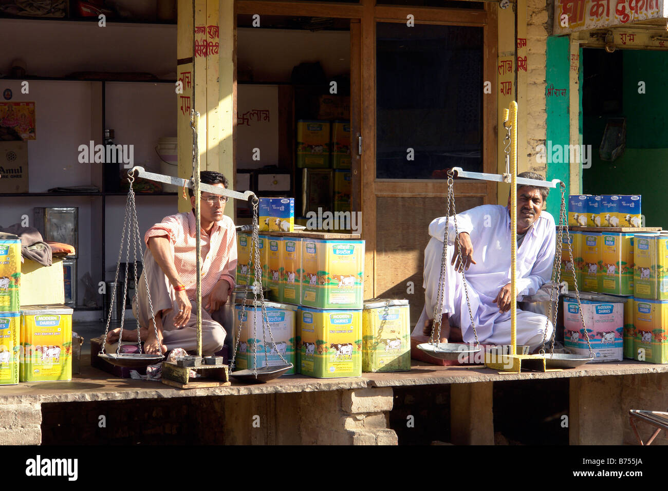 two indian shopkeepers in the bikaner market with traditional scales ...