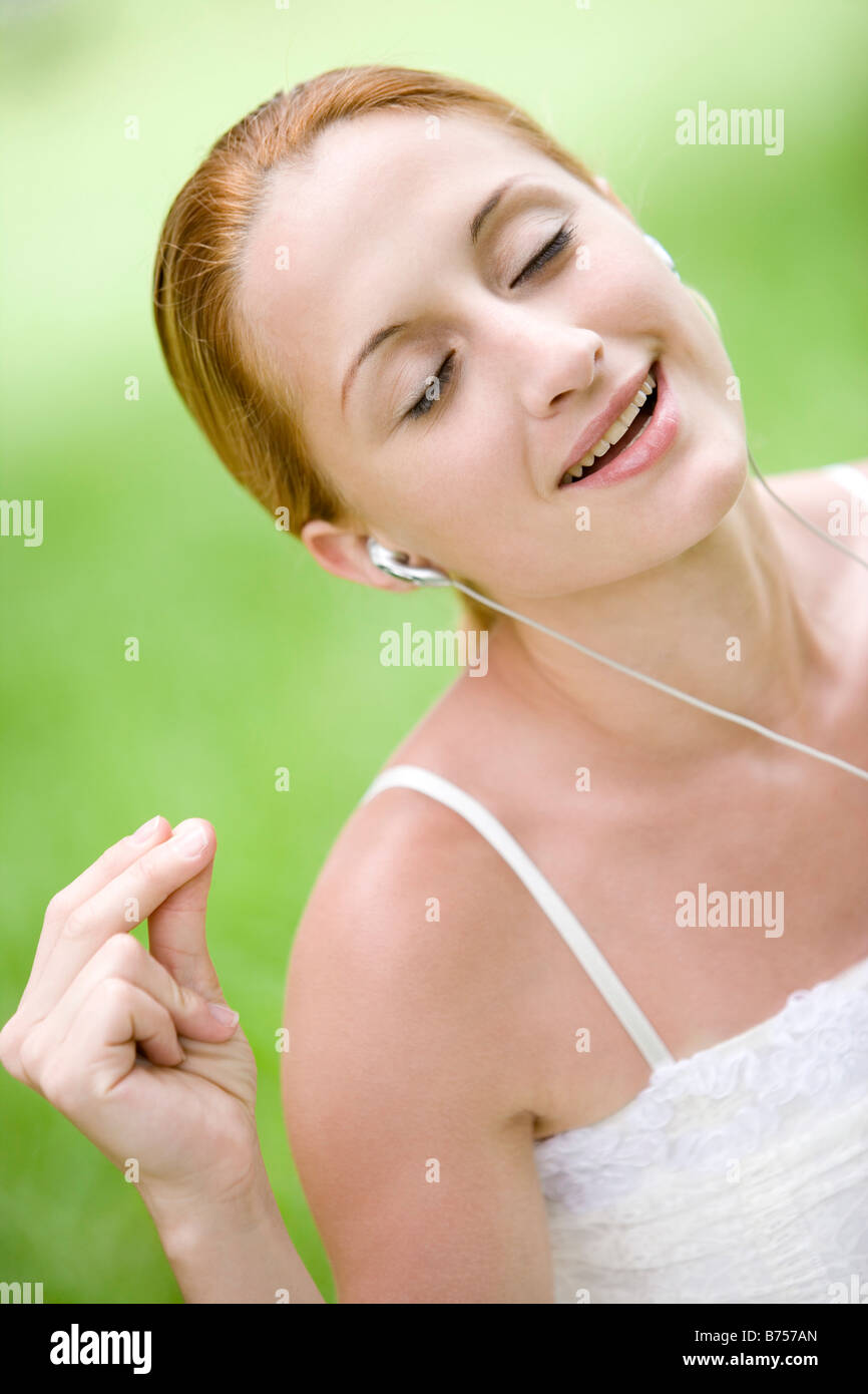 Young woman listening MP3 player portrait Stock Photo - Alamy
