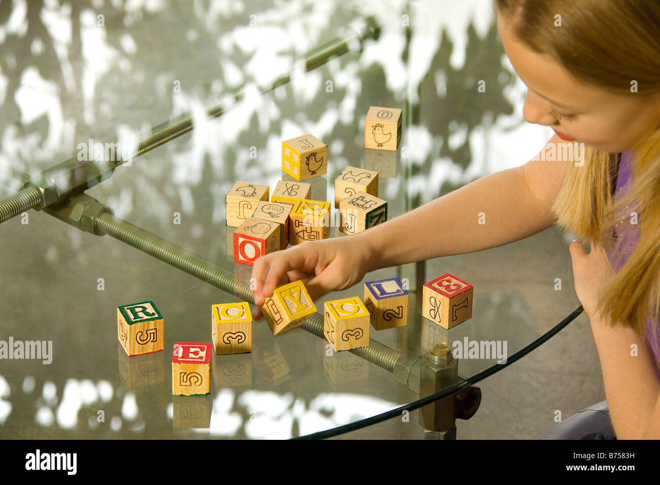 Young girl spelling recycle with alphabet blocks Stock Photo - Alamy
