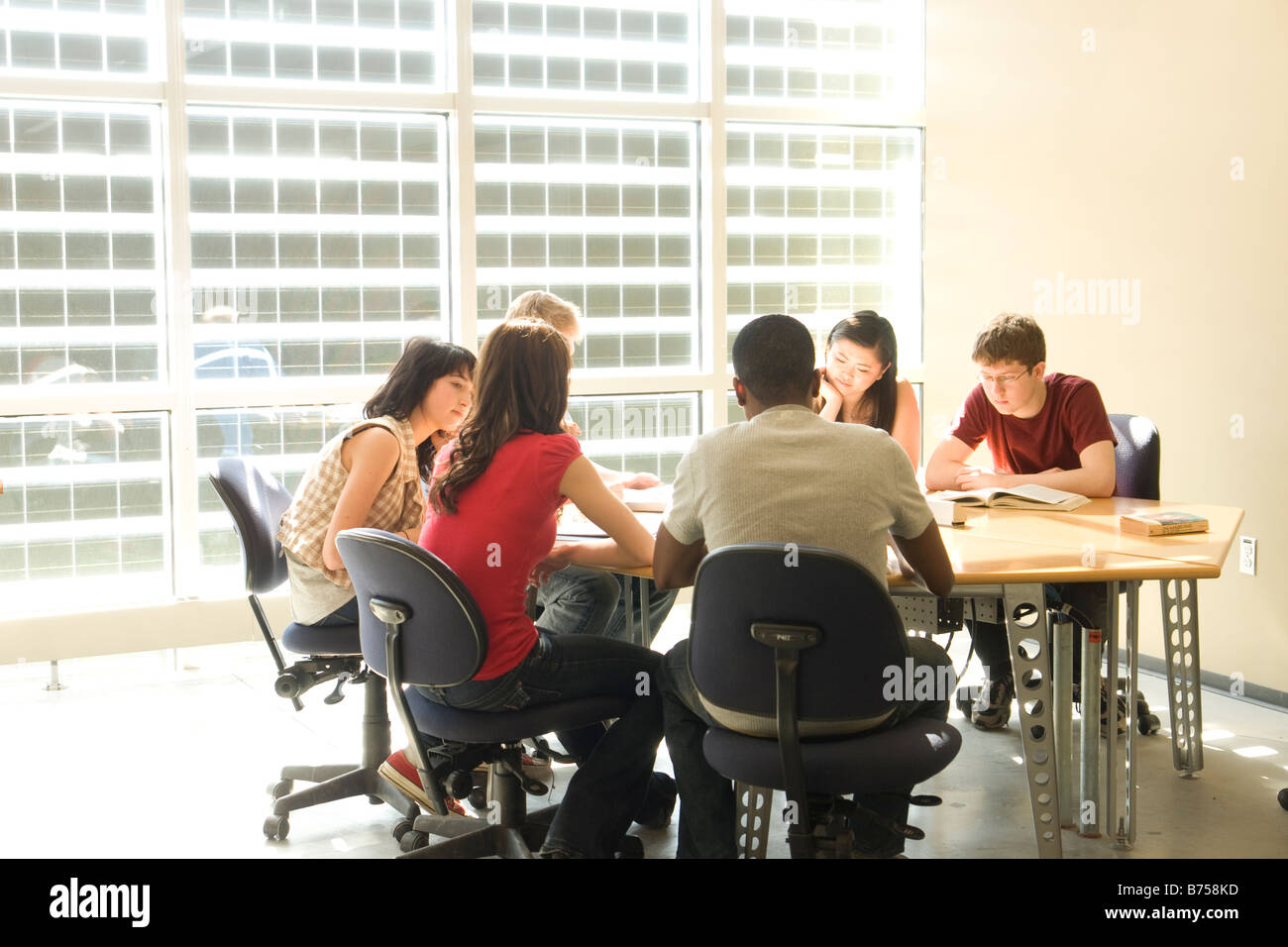 Group of students seated around table in front of solar panelled ...