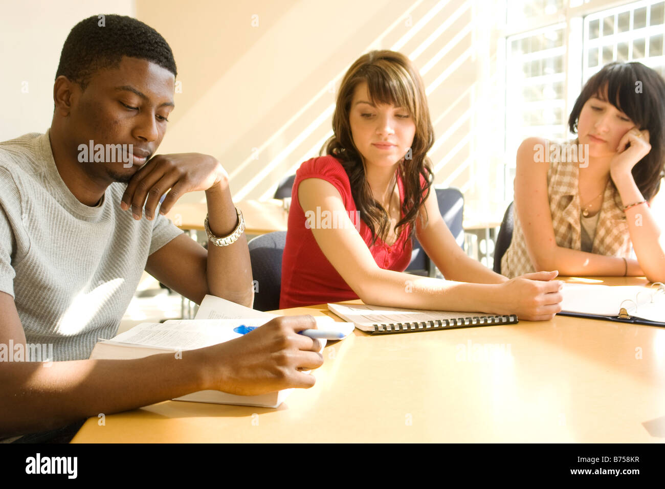 Three students seated at table, solar panels in background, Winnipeg ...