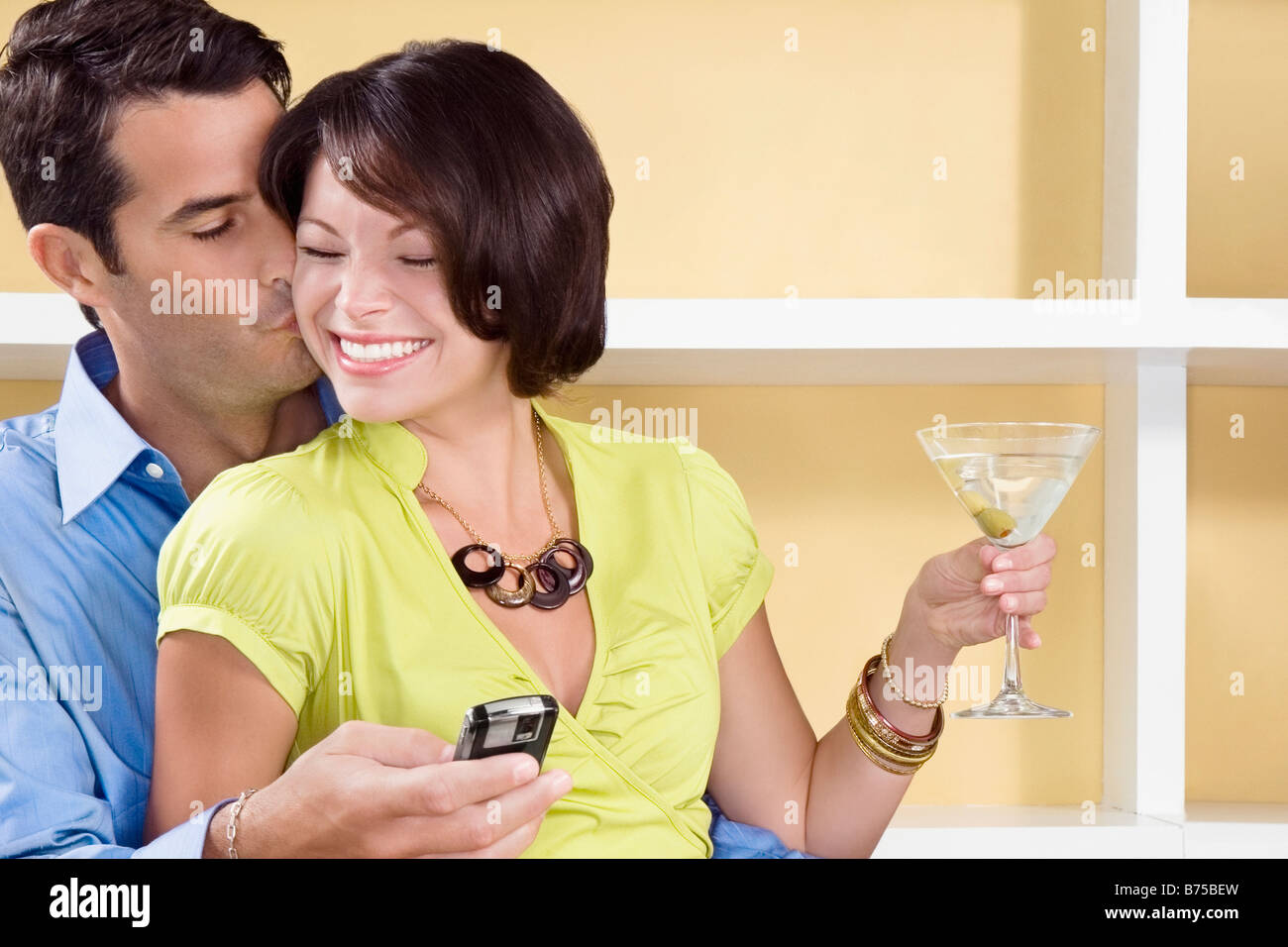 Mid adult man kissing a young woman smiling Stock Photo - Alamy