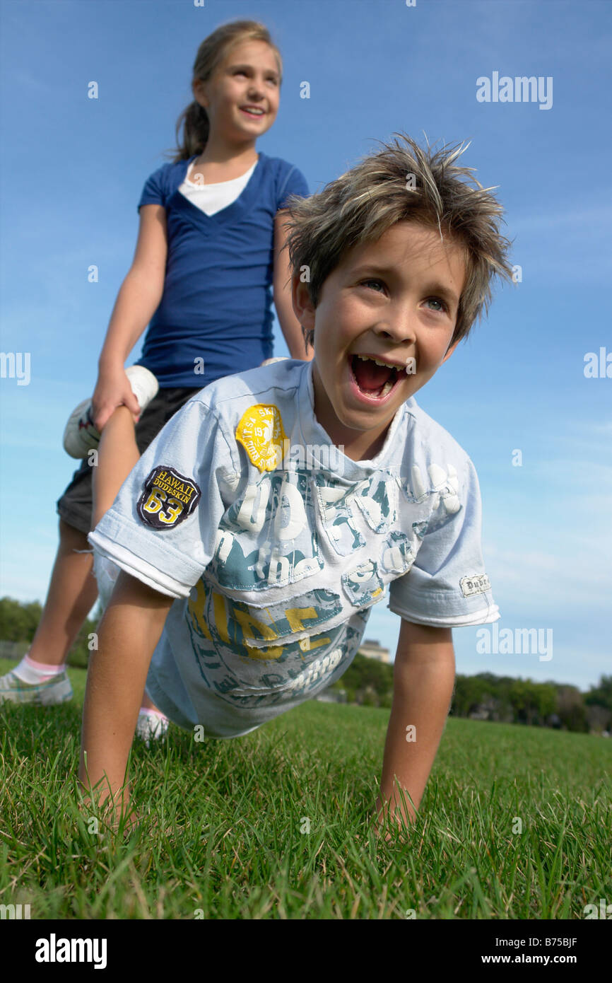 Eight year old boy and girl playing wheelbarrow, Winnipeg, Manitoba ...