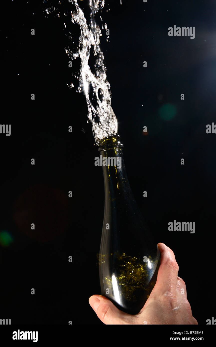 Champagne bursting from a bottle on black background Stock Photo - Alamy