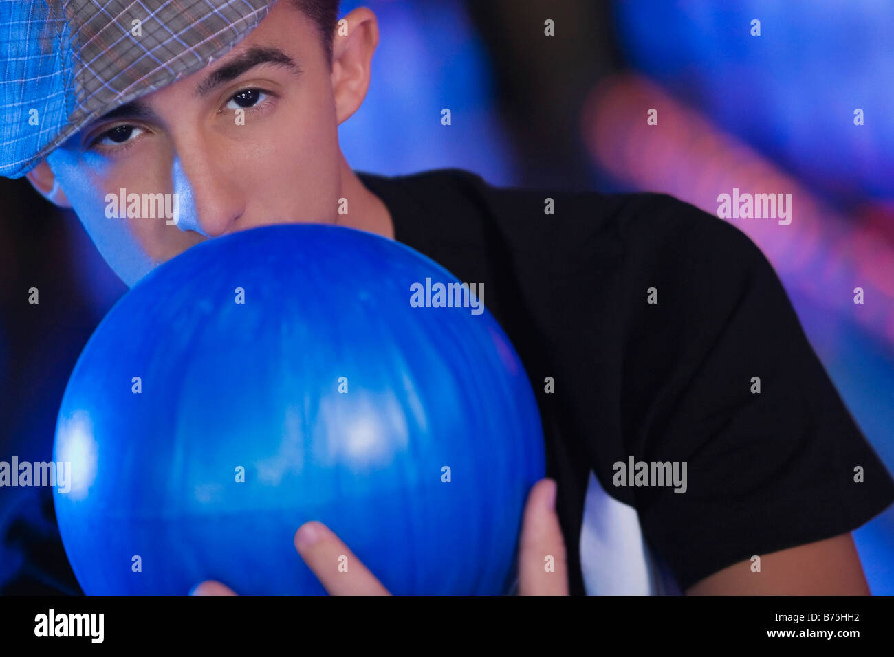 Portrait of a young man holding a bowling ball Stock Photo - Alamy