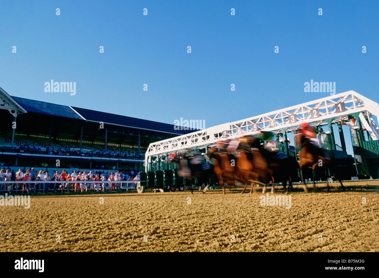 Jockeys riding their horses on a running track Stock Photo - Alamy