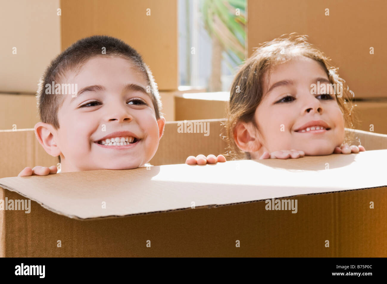 Close-up of a boy and a girl smiling in a cardboard box Stock Photo - Alamy