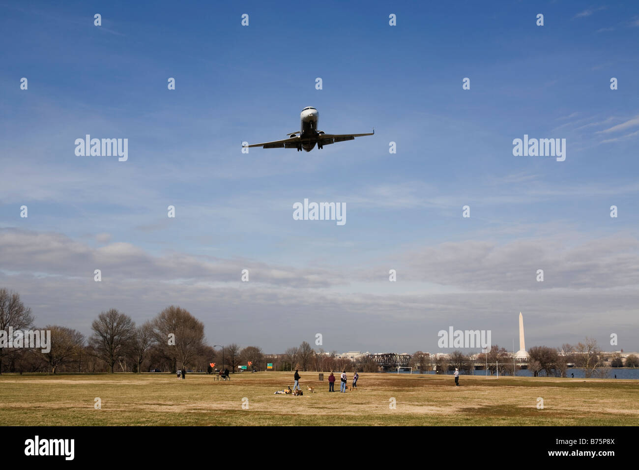A commuter airplane flying over a city park Stock Photo - Alamy