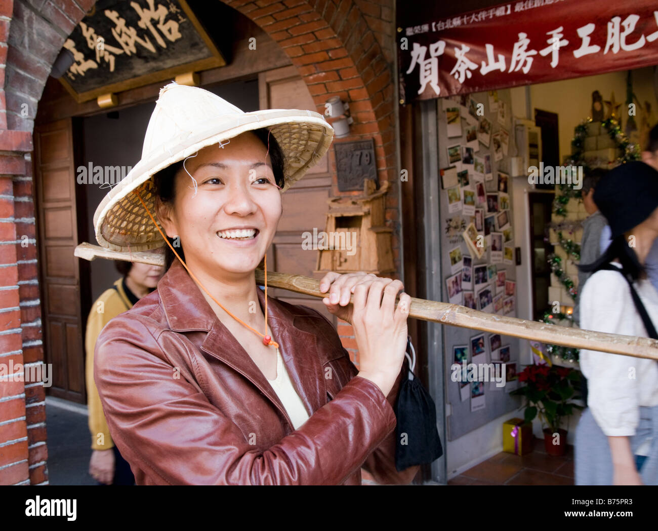 oriental beautiful girl in traditional straw hat carrying pole on her ...